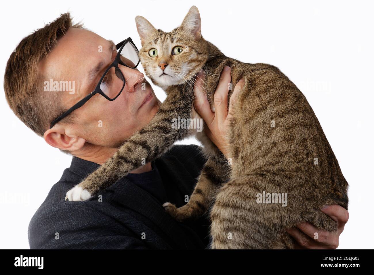 A man in glasses holds a cat in his hands and looks at her attentively ...