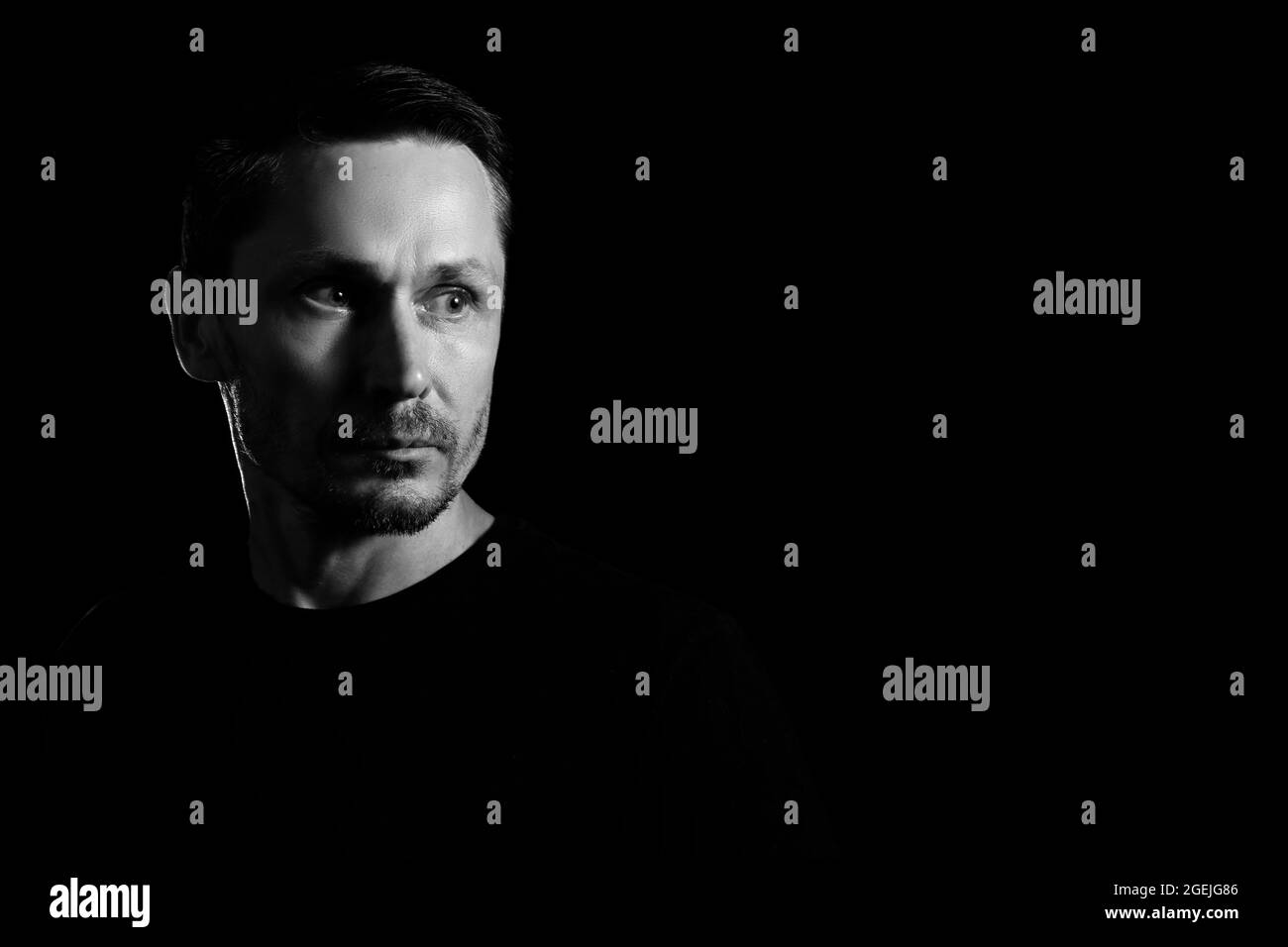 Black and white portrait of an unshaven sad man in a pensive mood ...