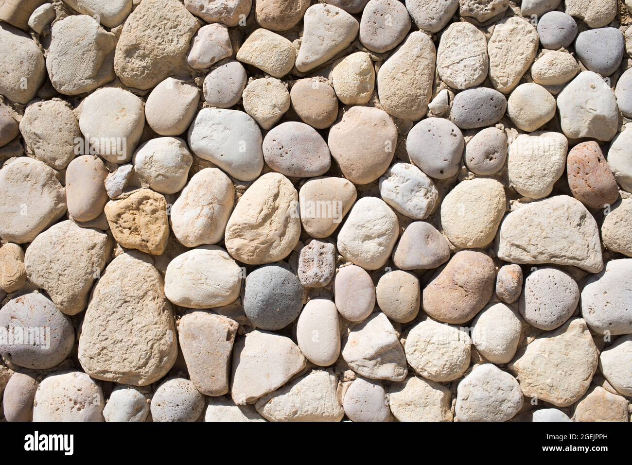 Stone wall made of stones with different shapes and tones. Traditional ...