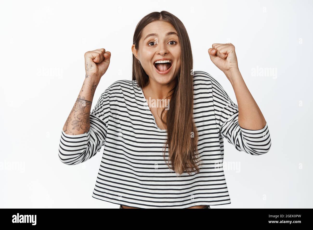 Celebration concept. Happy smiling girl jumping from happiness, raising ...