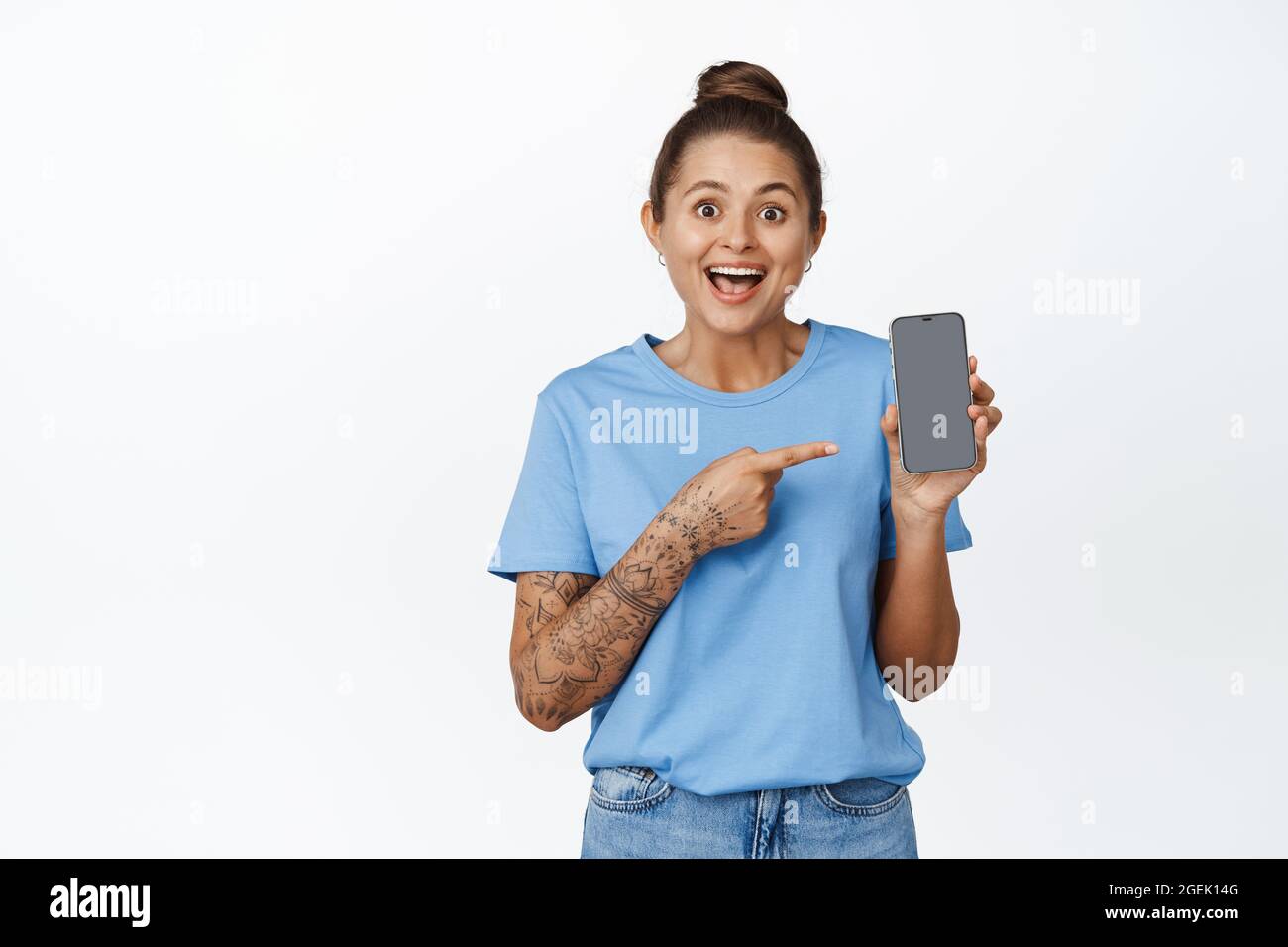 Happy smiling girl pointing finger at mobile phone, showing interface ...