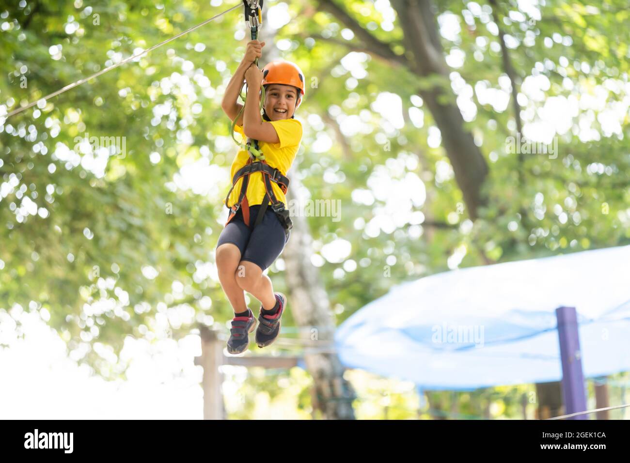 Happy child climbing in the trees. Rope park. Climber child. Early ...