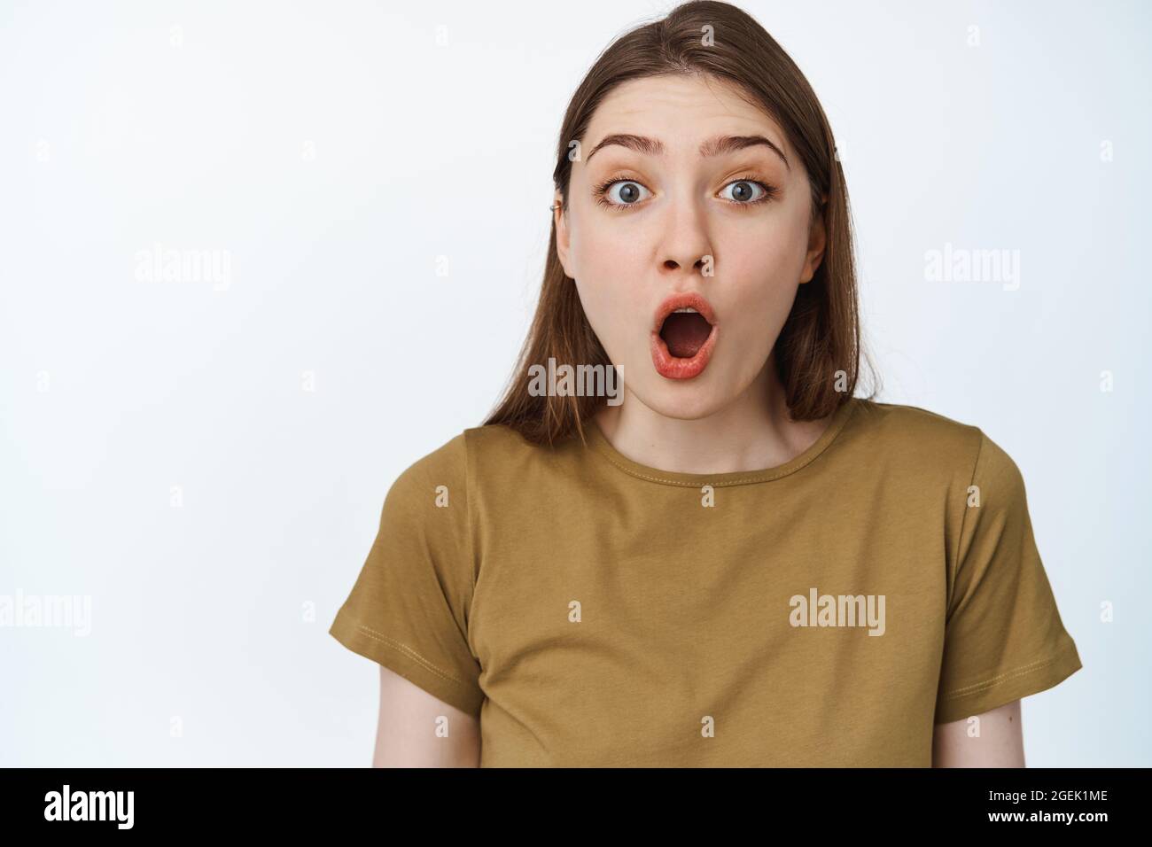Face of surprised beautiful girl, saying wow, looking impressed at ...