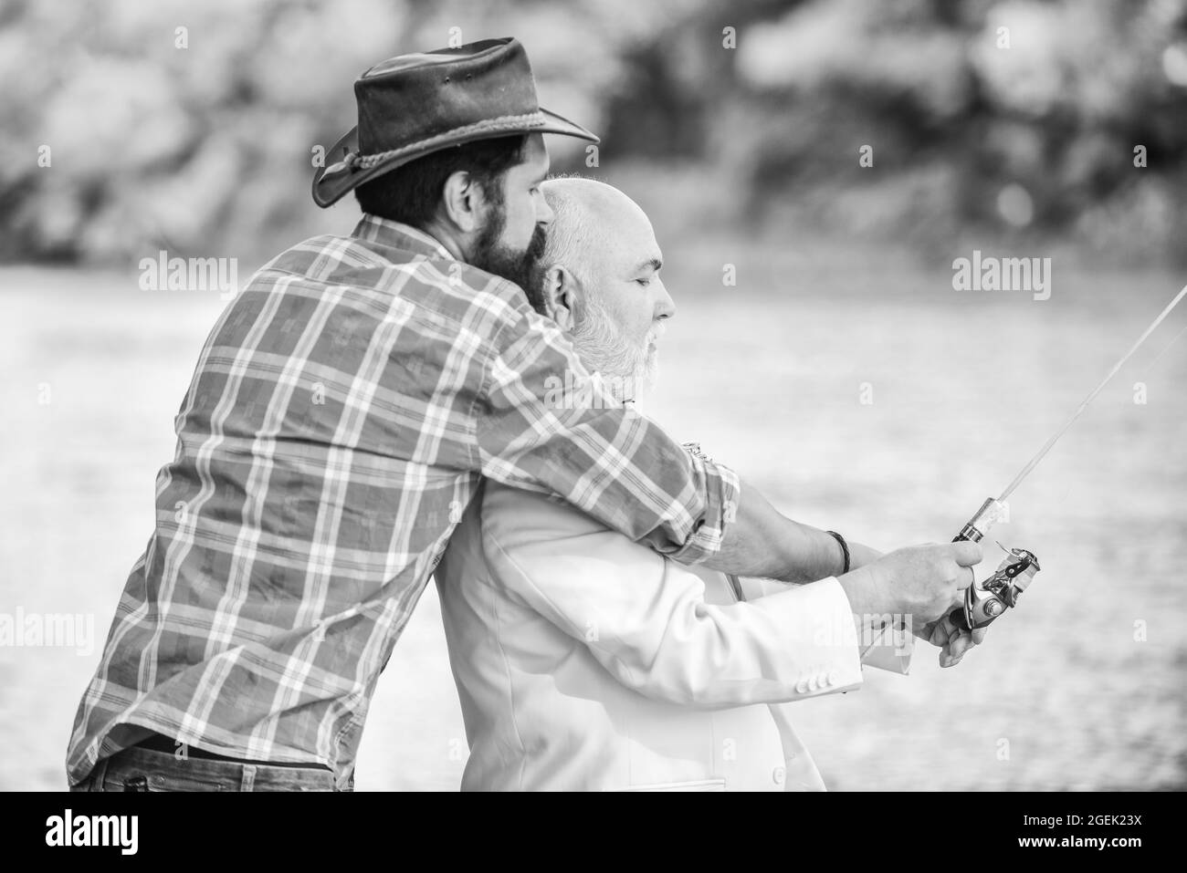 Bearded man and elegant businessman fish together. Learn to fish ...
