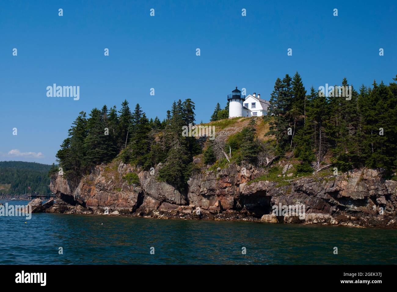 Bear Island lighthouse sits on top of rocky cliffs among evergreen ...