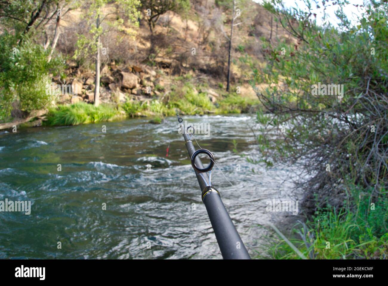 Fishing rod over a fast-moving creek Stock Photo - Alamy