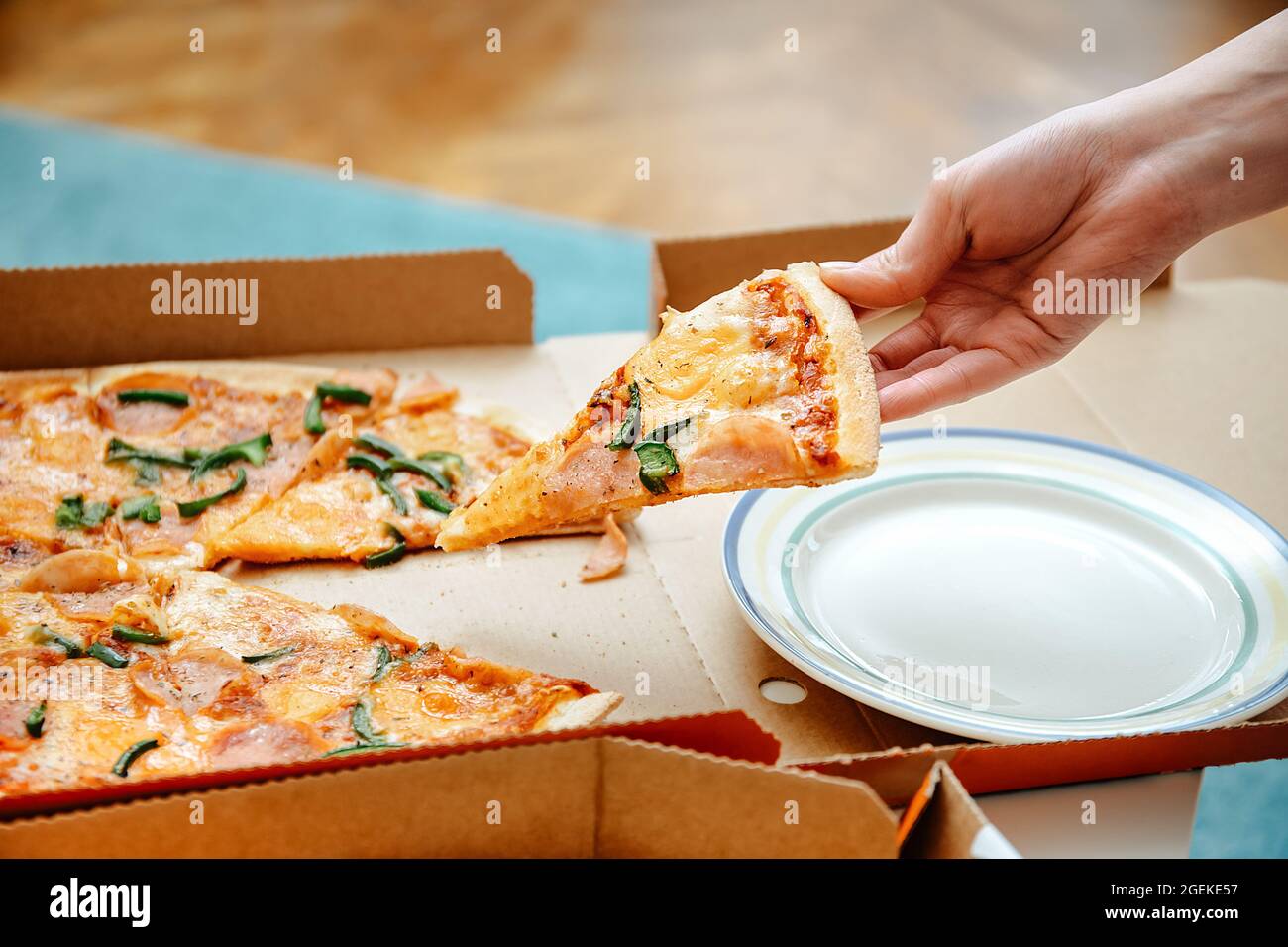 Woman hand holding pizza slice from pizza circle. Woman grabbing tasty ...