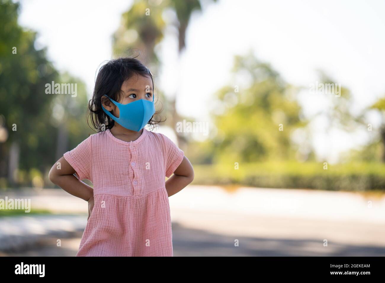 Beautiful Southeast Asian female kid with a mask on her face in the ...