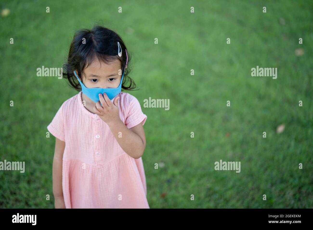 Beautiful Southeast Asian female kid with a mask on her face in the ...