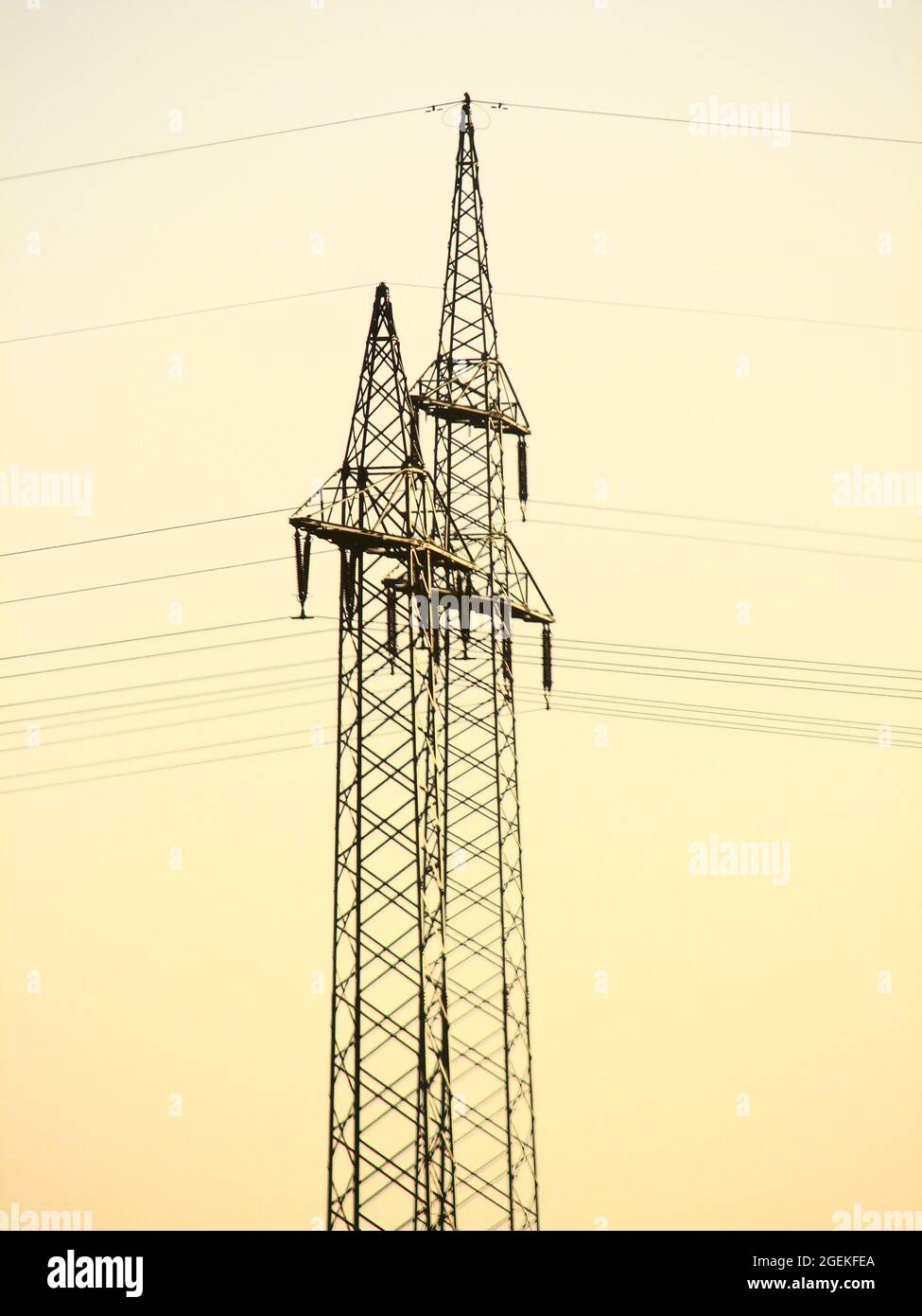 Electrical network towers on a clear yellow background Stock Photo - Alamy