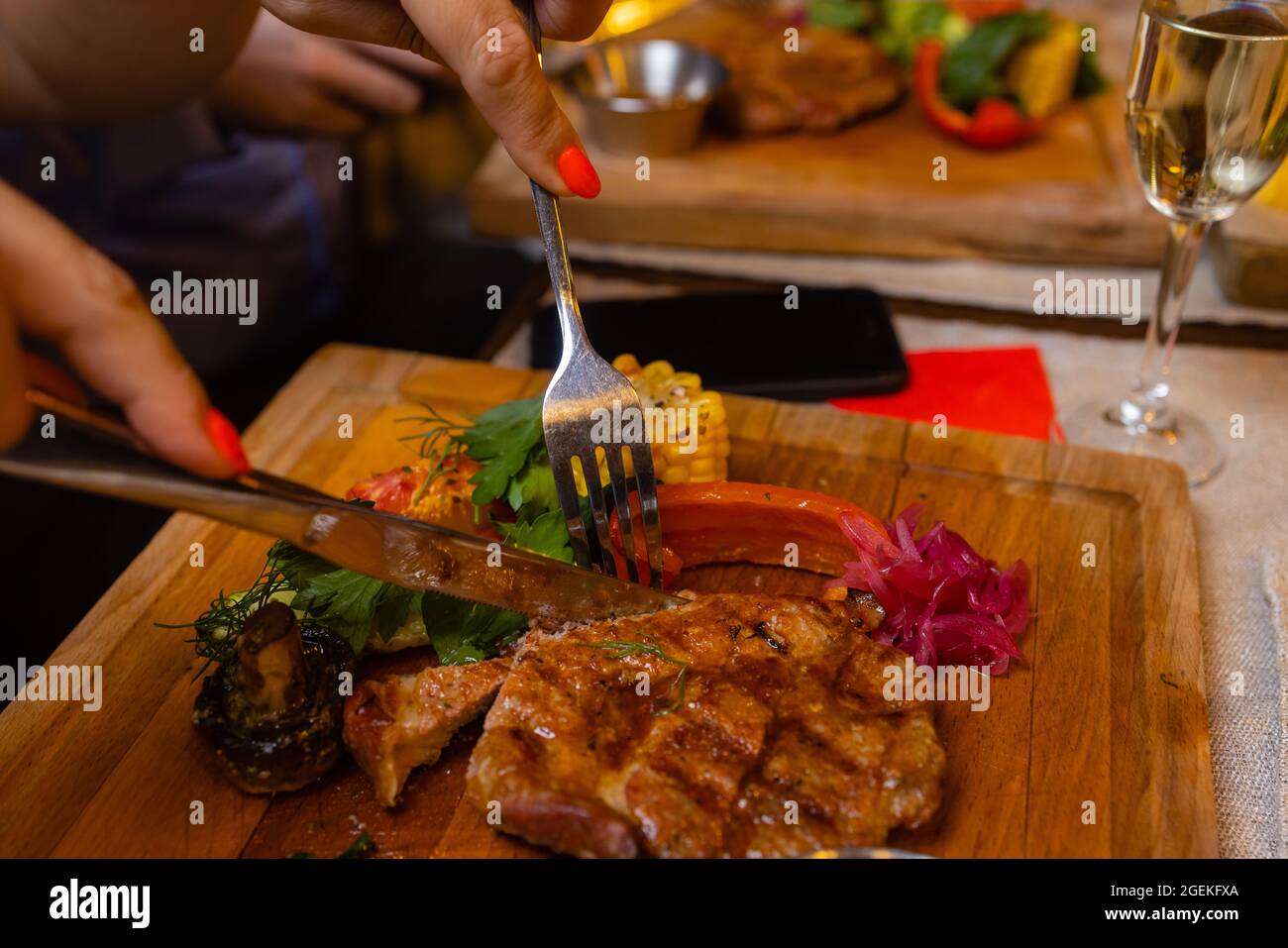 Young woman eating grilled steak in restaurant Stock Photo - Alamy