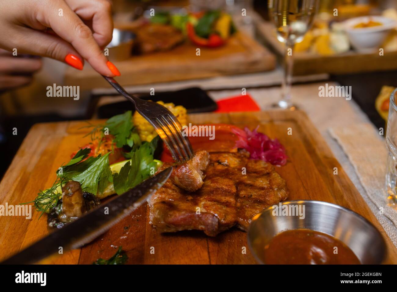 Young woman eating grilled steak in restaurant Stock Photo - Alamy