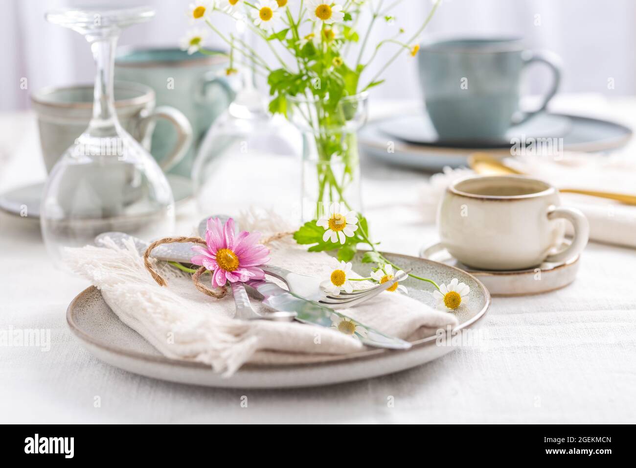 Spring and summer place setting with fresh flowers, cutlery and coffee ...
