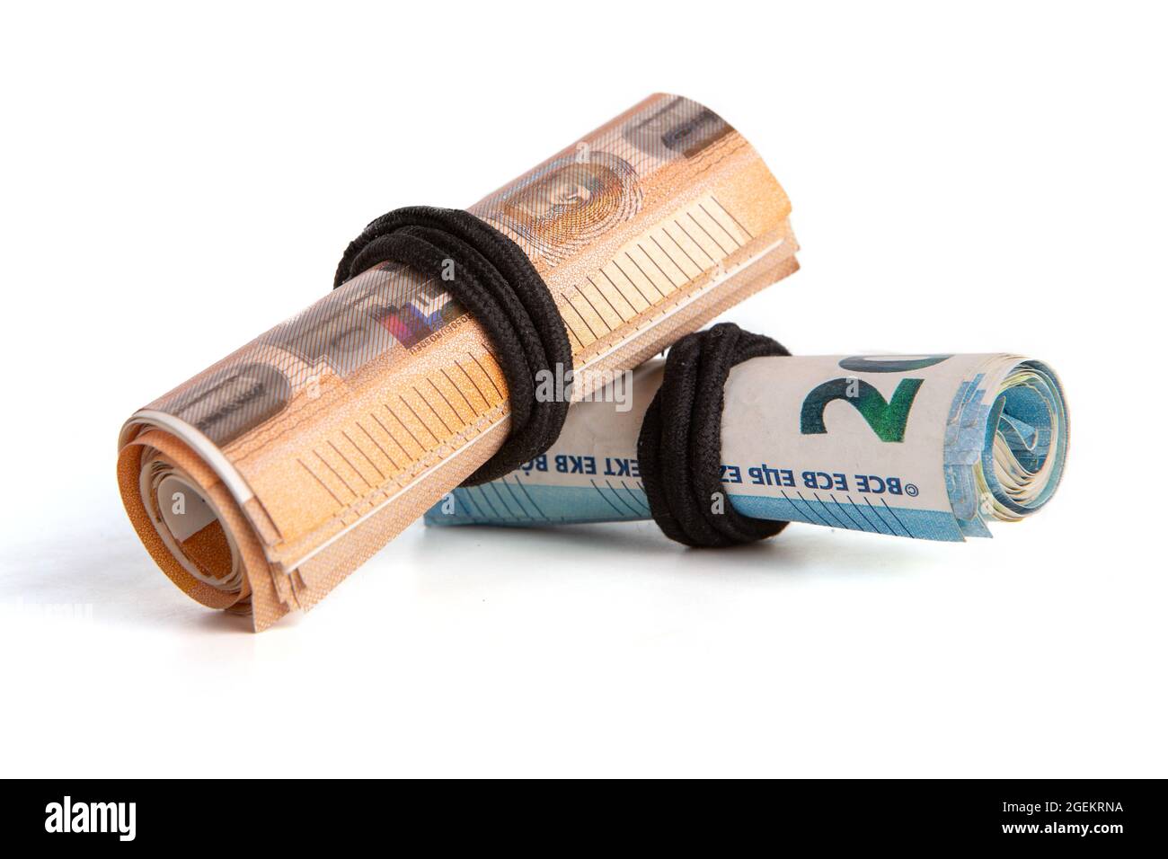 Roll of euro banknotes tied with a rubber band on a white background ...