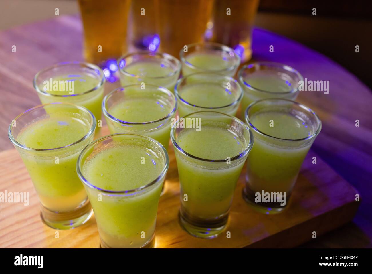 Green liquid in shot glasses standing on the counter Stock Photo - Alamy