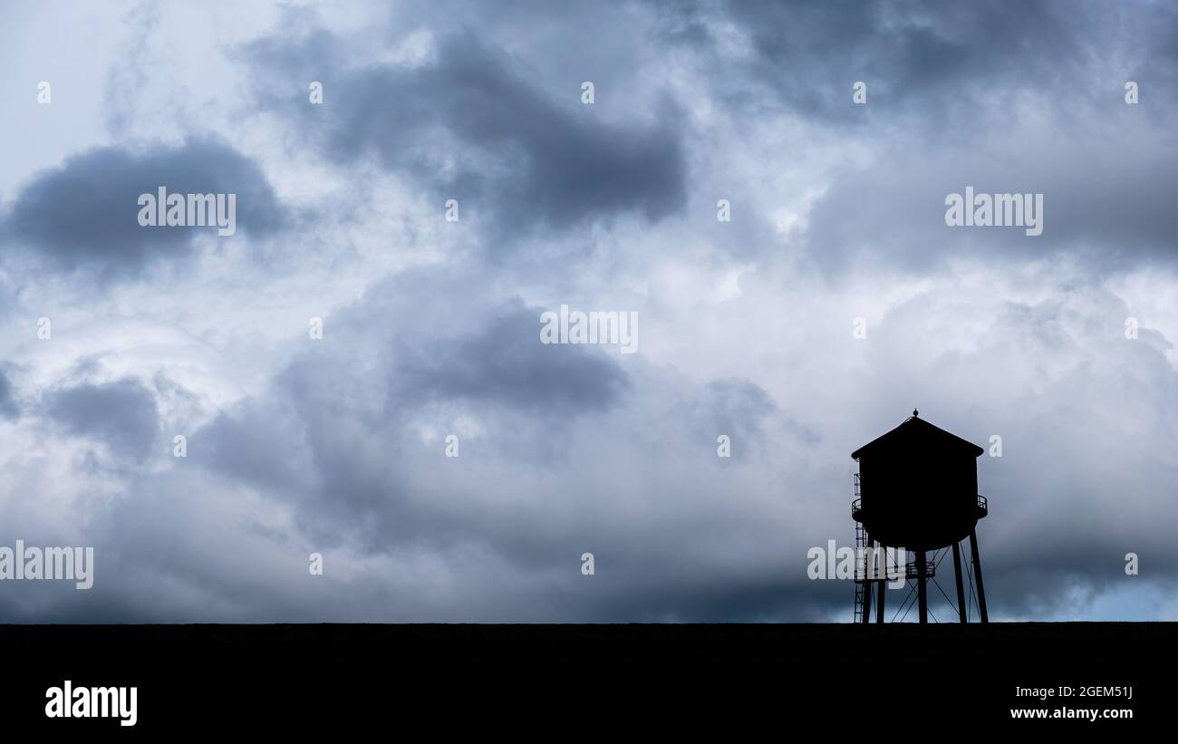 Water tower in silhouette with dramatic clouds in background at Camp ...
