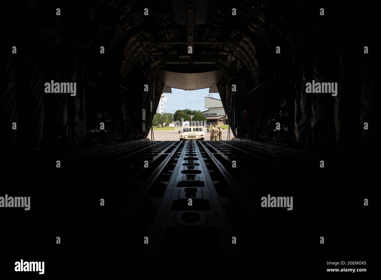 A humvee sits on the tarmac ready to be loaded onto a C-130J aircraft ...