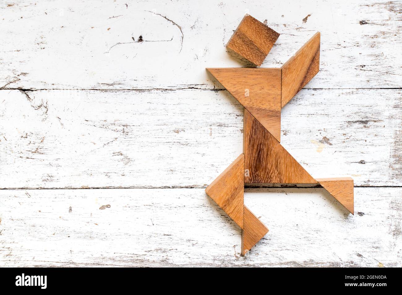 Tangram puzzle in happy running or dancing man shape on old white wood ...