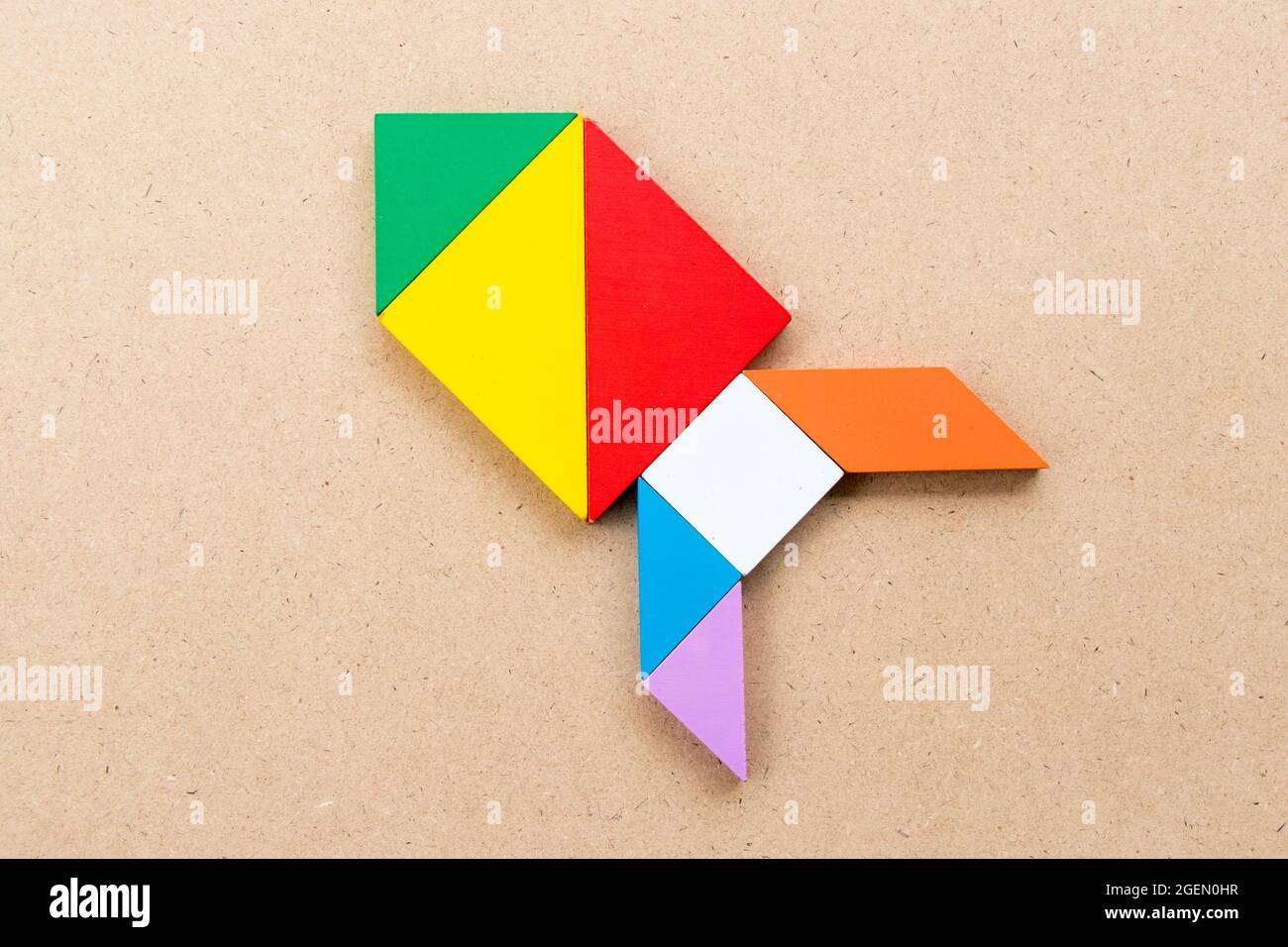 Color tangram puzzle in rocket or missile shape on wood background ...