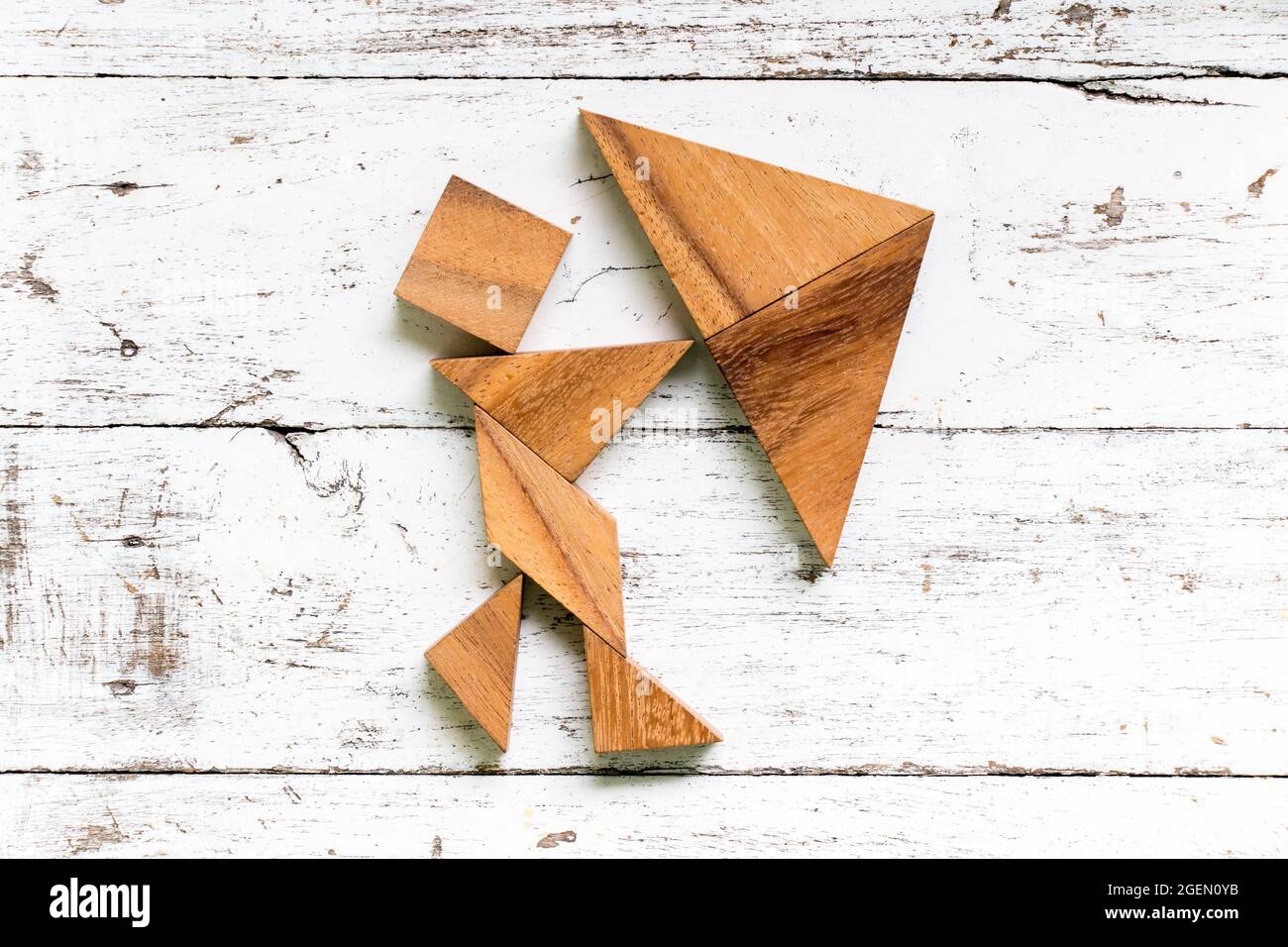 Tangram puzzle in man hold umbrella shape on old white wood background ...