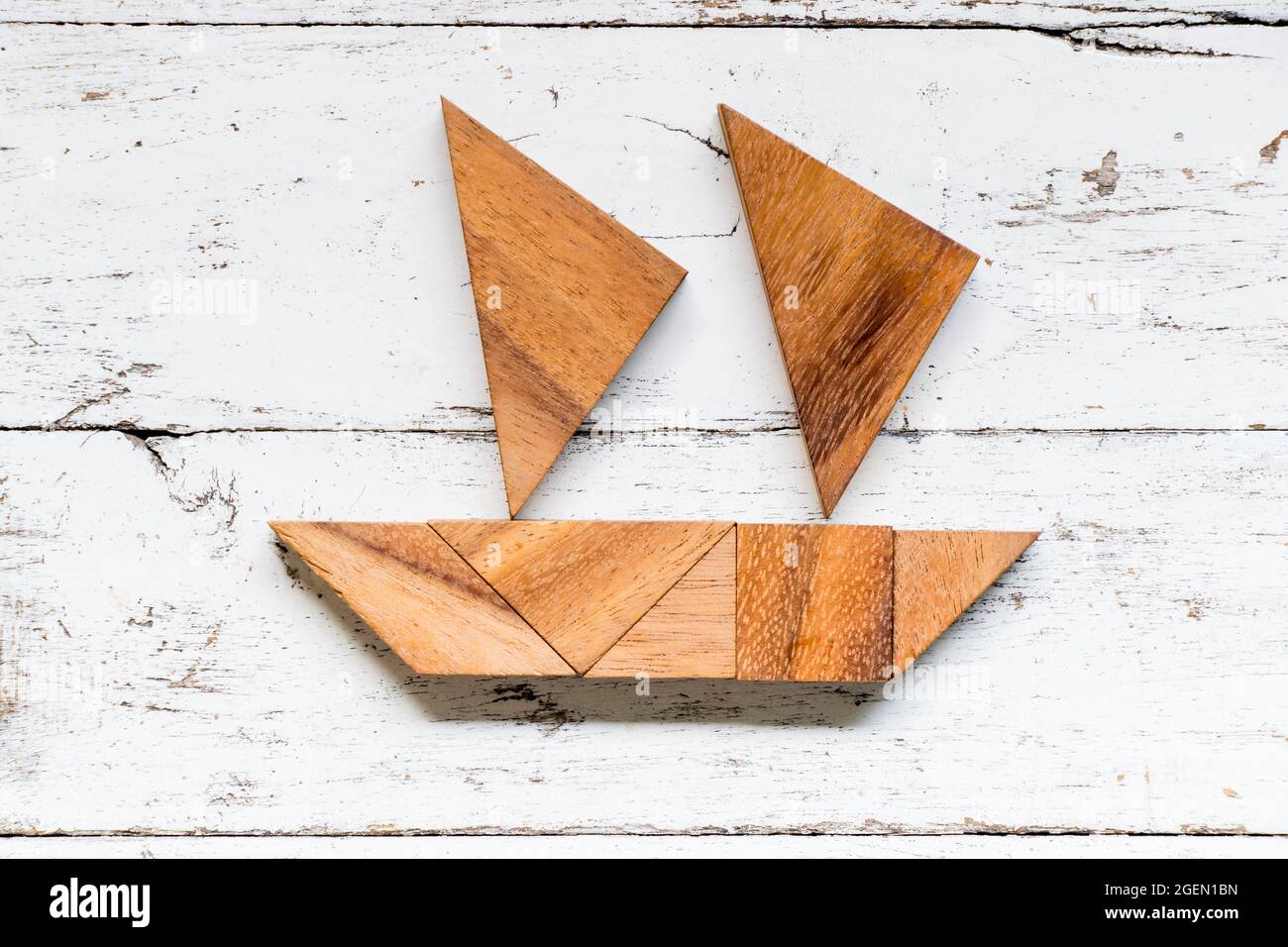 Tangram puzzle in sail boat or yacht shape on old white wood background ...