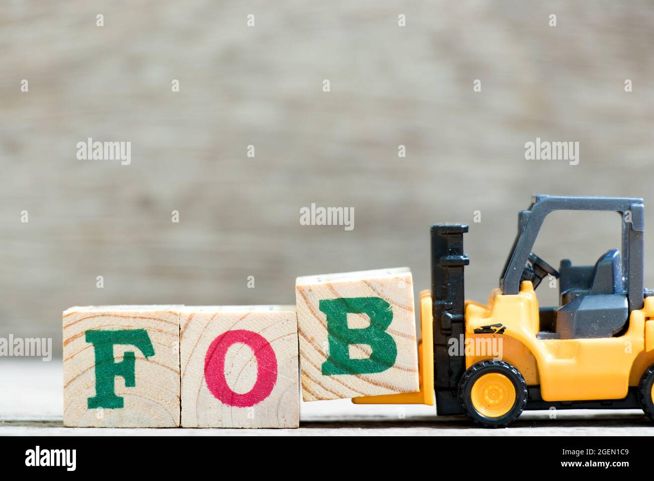 Toy forklift hold letter block B in word FOB (abbreviation of Free On ...