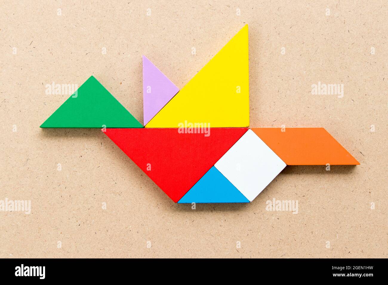 Color tangram puzzle in flying bird shape on wood background Stock ...