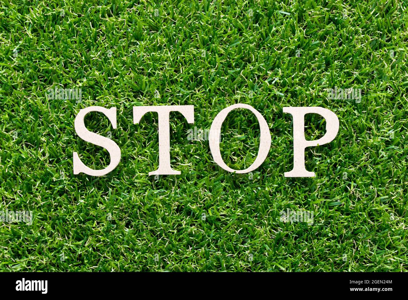 Wood alphabet in word stop on artificial green grass background Stock ...