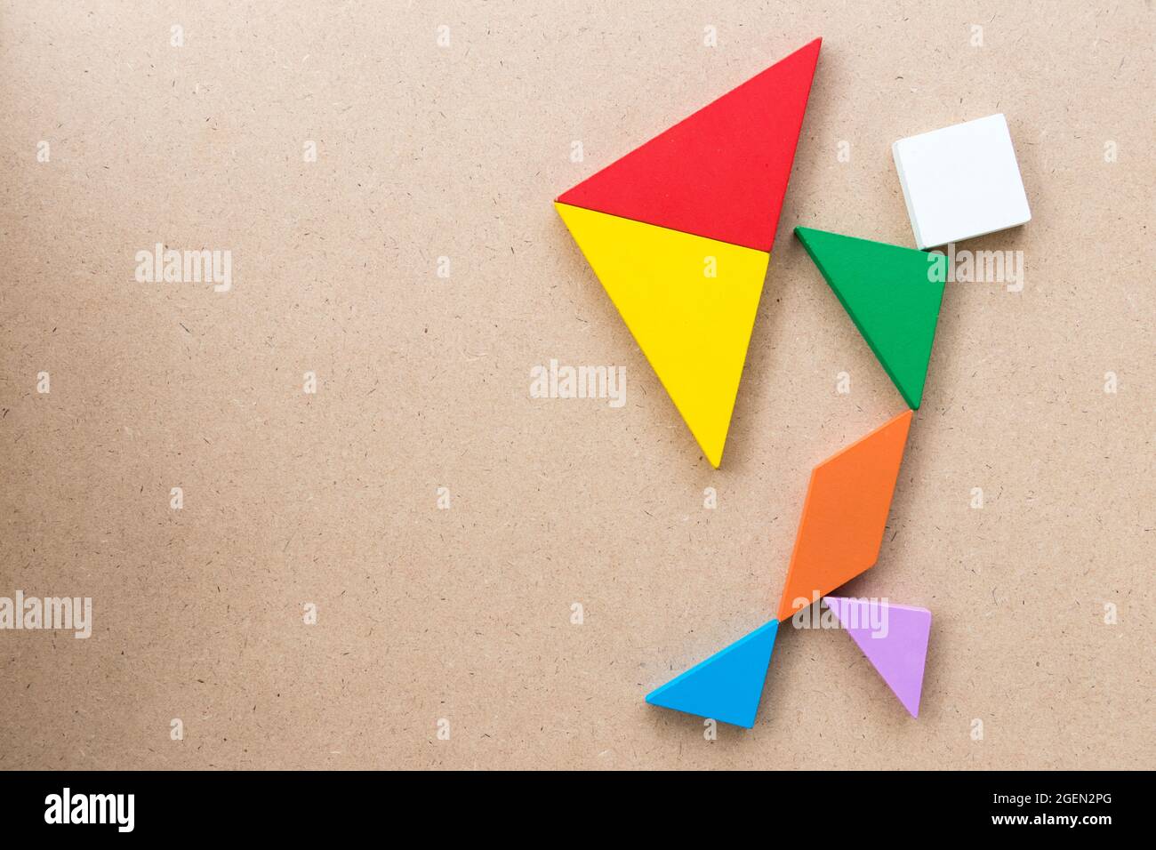Color tangram puzzle in man hold umbrella shape on wood background ...