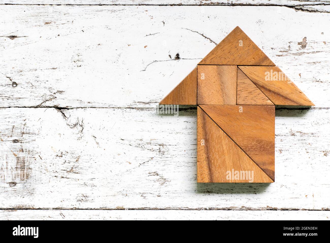 Tangram puzzle in direction arrow shape on old white wood background ...