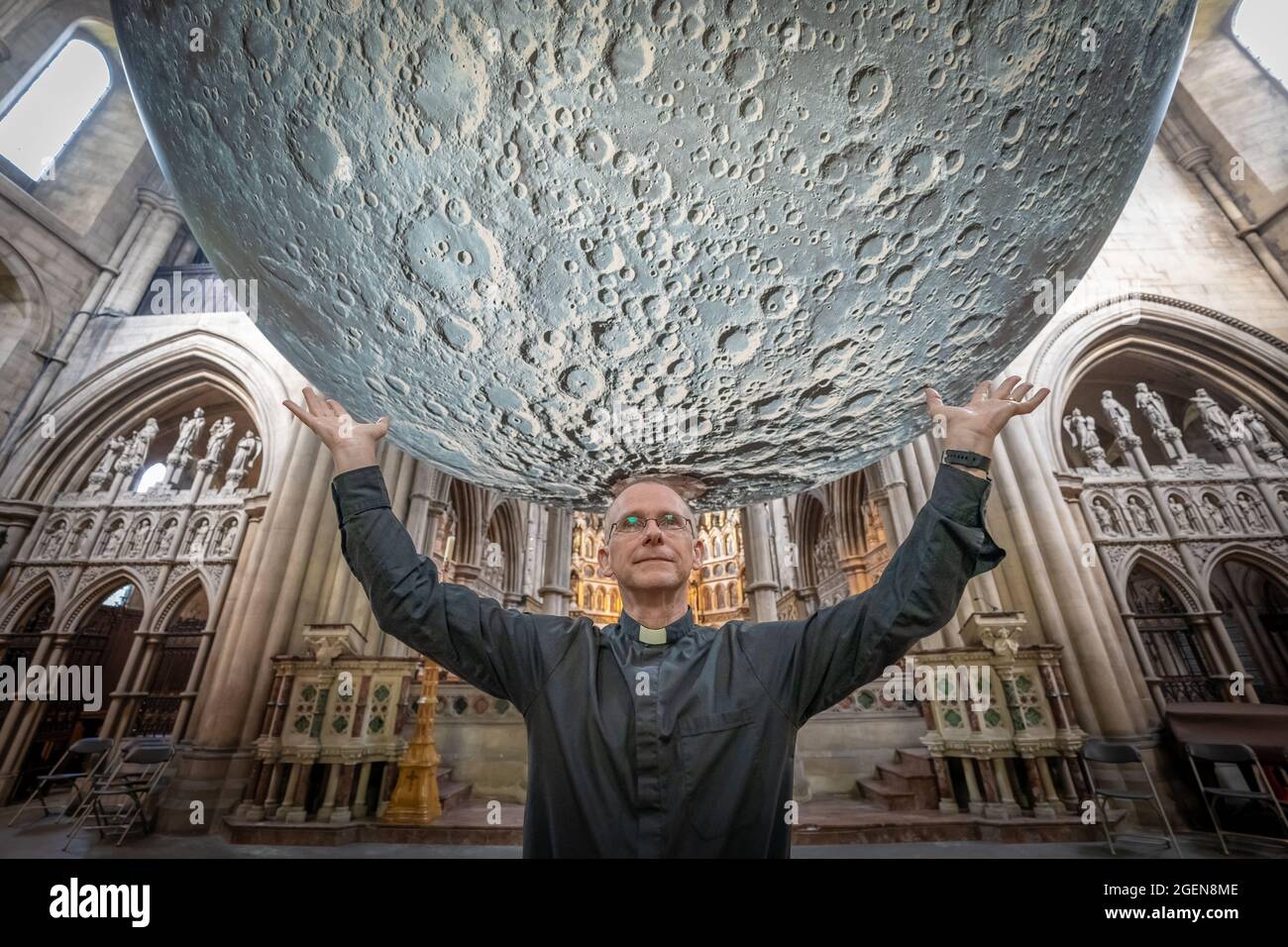 Resident Vicar, James Heard, stands with Museum of the Moon ...