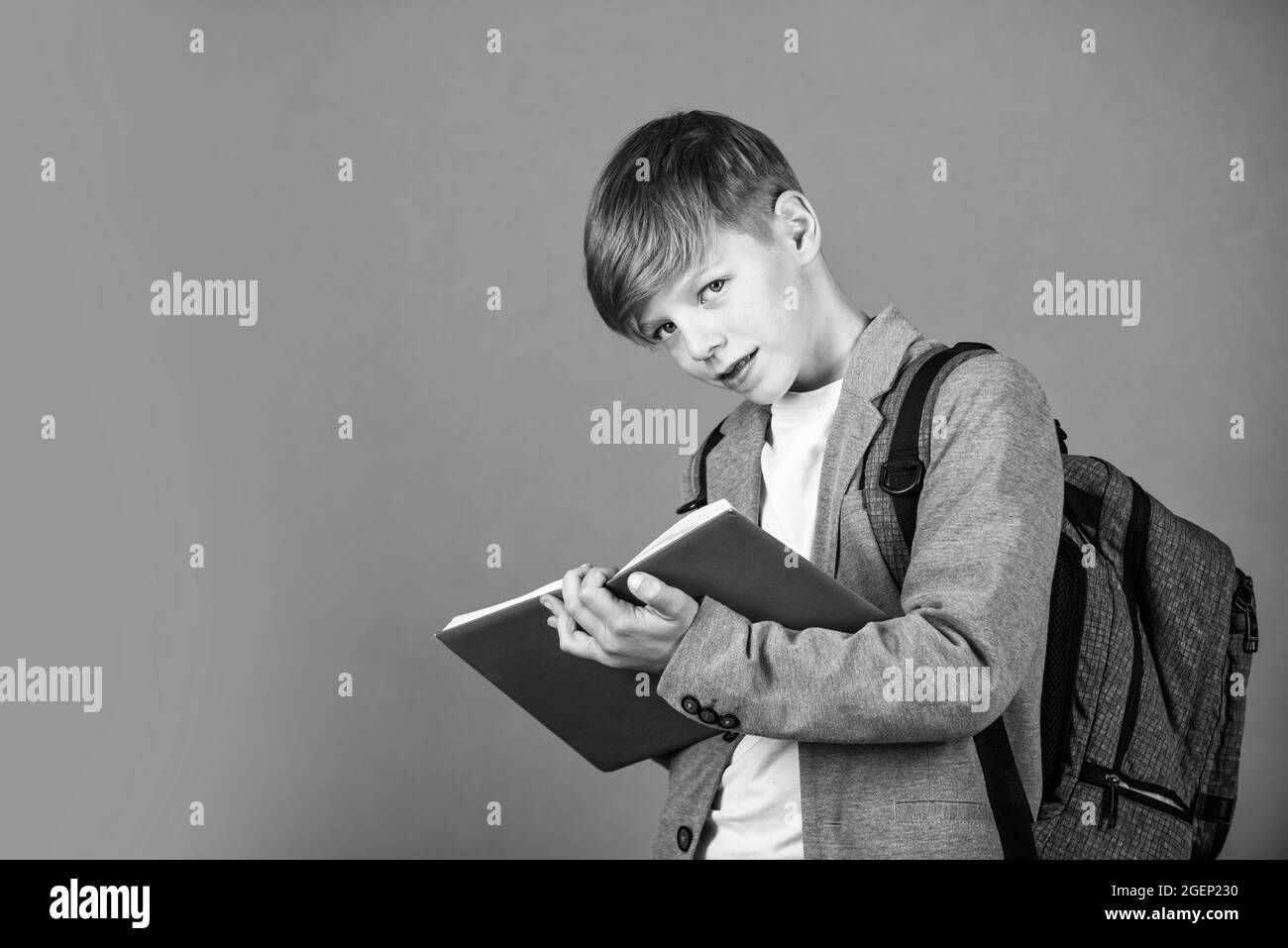 Final exam. Little child take exam brown background. Small boy write in ...