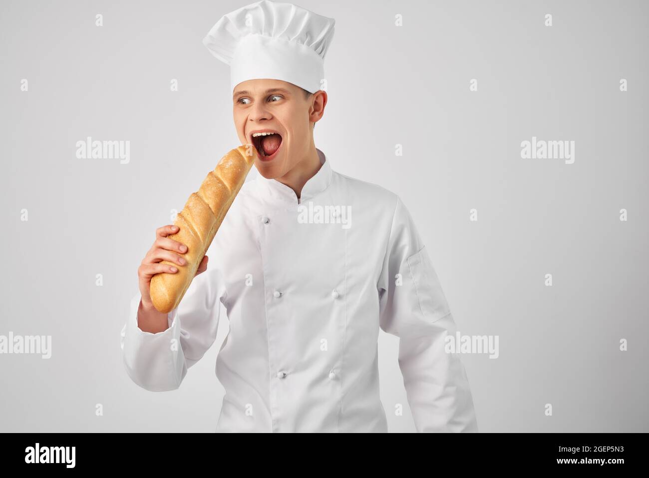Cheerful male chef biting a loaf cooking food bakery Stock Photo - Alamy