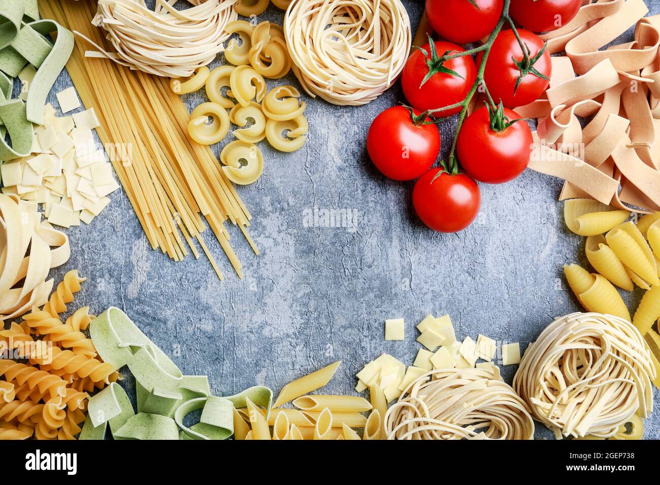 Mixed types and shapes of italian pasta on grey stone, background. Copy ...