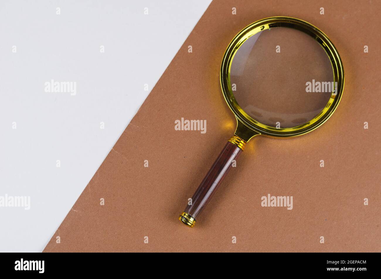 Magnifying glass in a gold frame on a two-color background. Minimalist ...