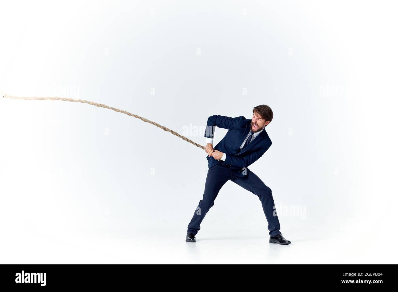 business man in suit pulling rope Studio team work Stock Photo - Alamy