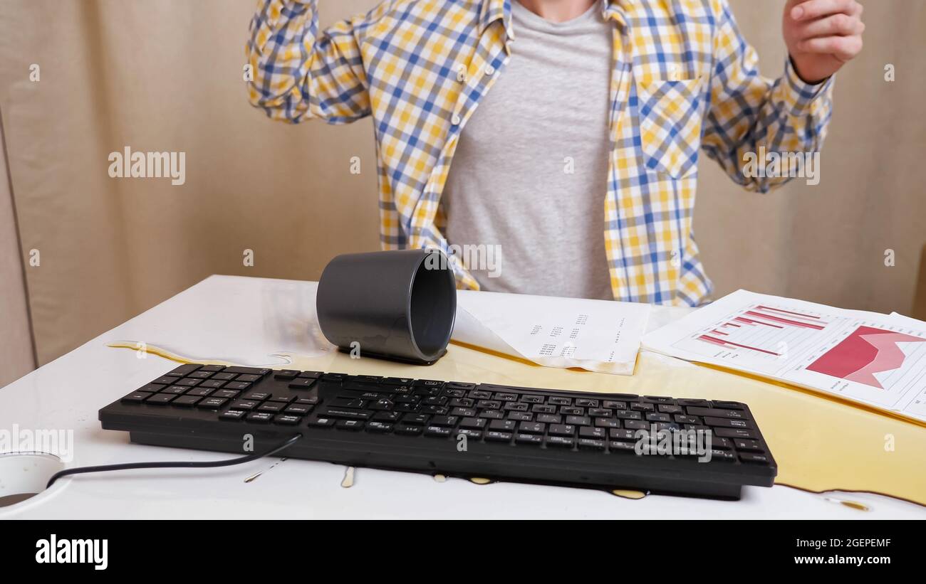 Unrecognizable man works with documents and types text on the keyboard ...