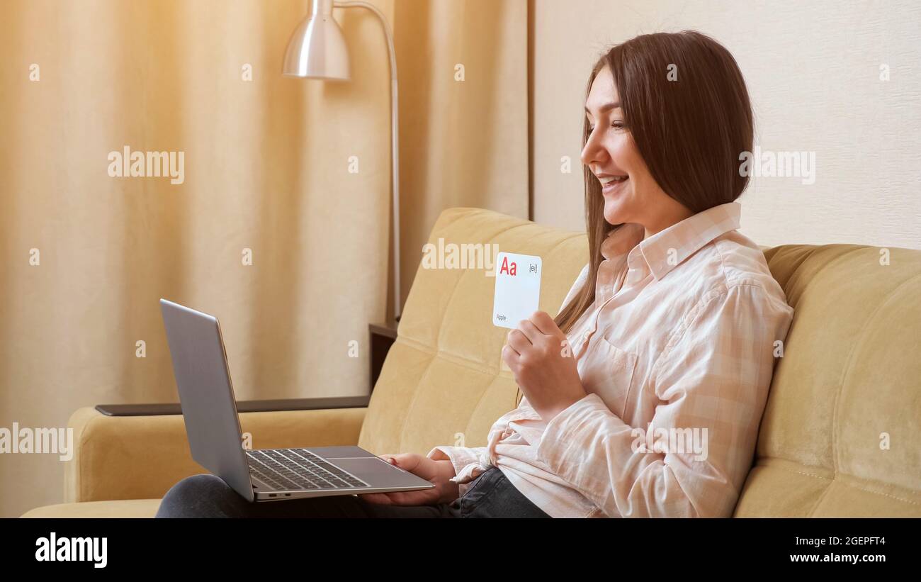 Woman with laptop demonstrates postcards with letters of the English ...