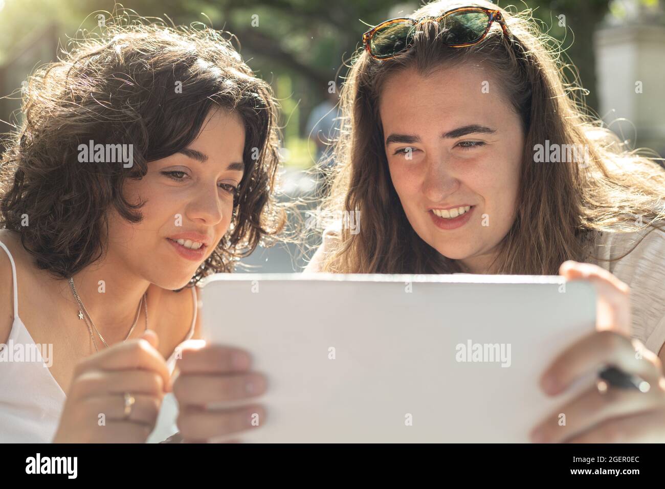two young people smiling and enjoying a tablet device while consulting ...