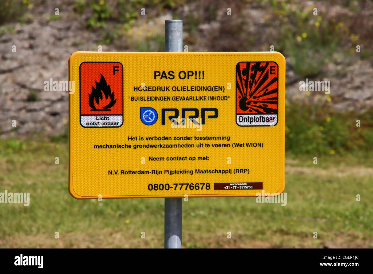 Warning sign for explosion or fire risk with Oil pipe in the ground in ...