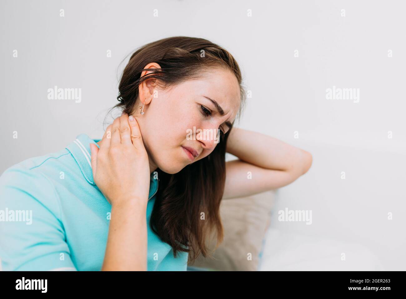 Woman thirties years old massages the neck from pinching the vertebrae ...