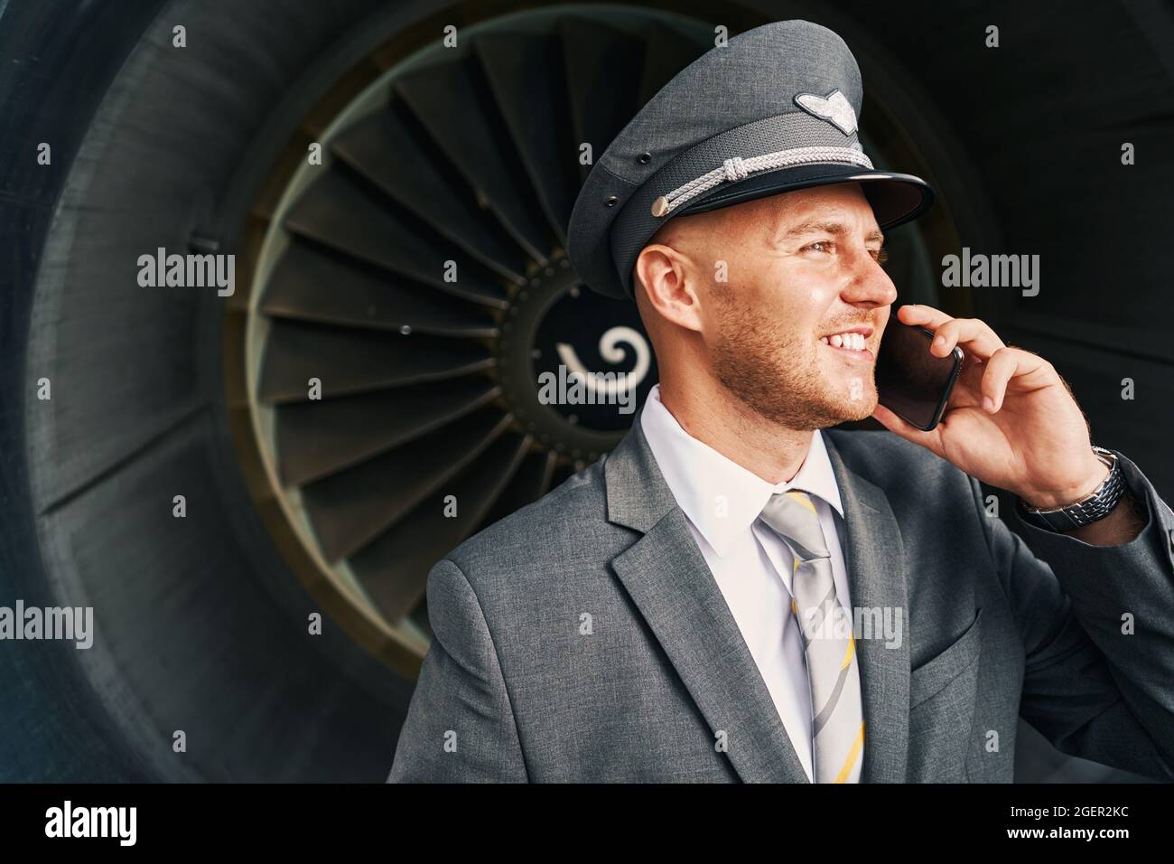 Joyful cute pilot having a phone conversation outdoors Stock Photo - Alamy