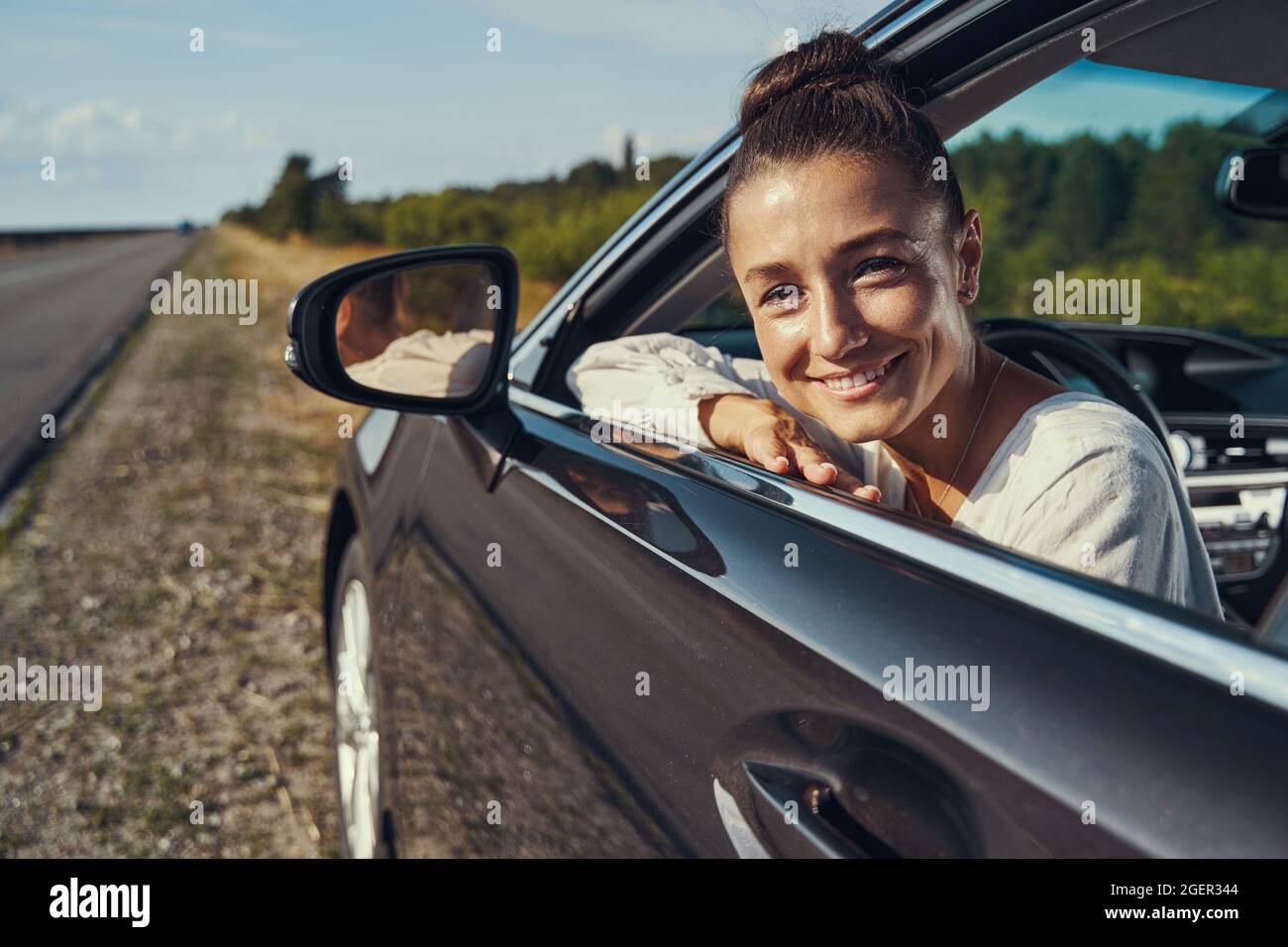Joyful driver looking out of car window Stock Photo - Alamy