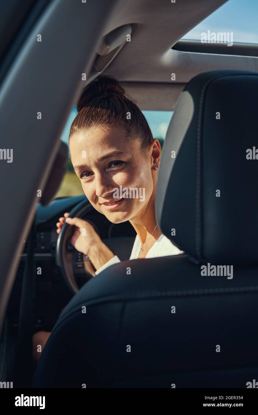 Driver turning and taking a look at rear seat of automobile Stock Photo ...