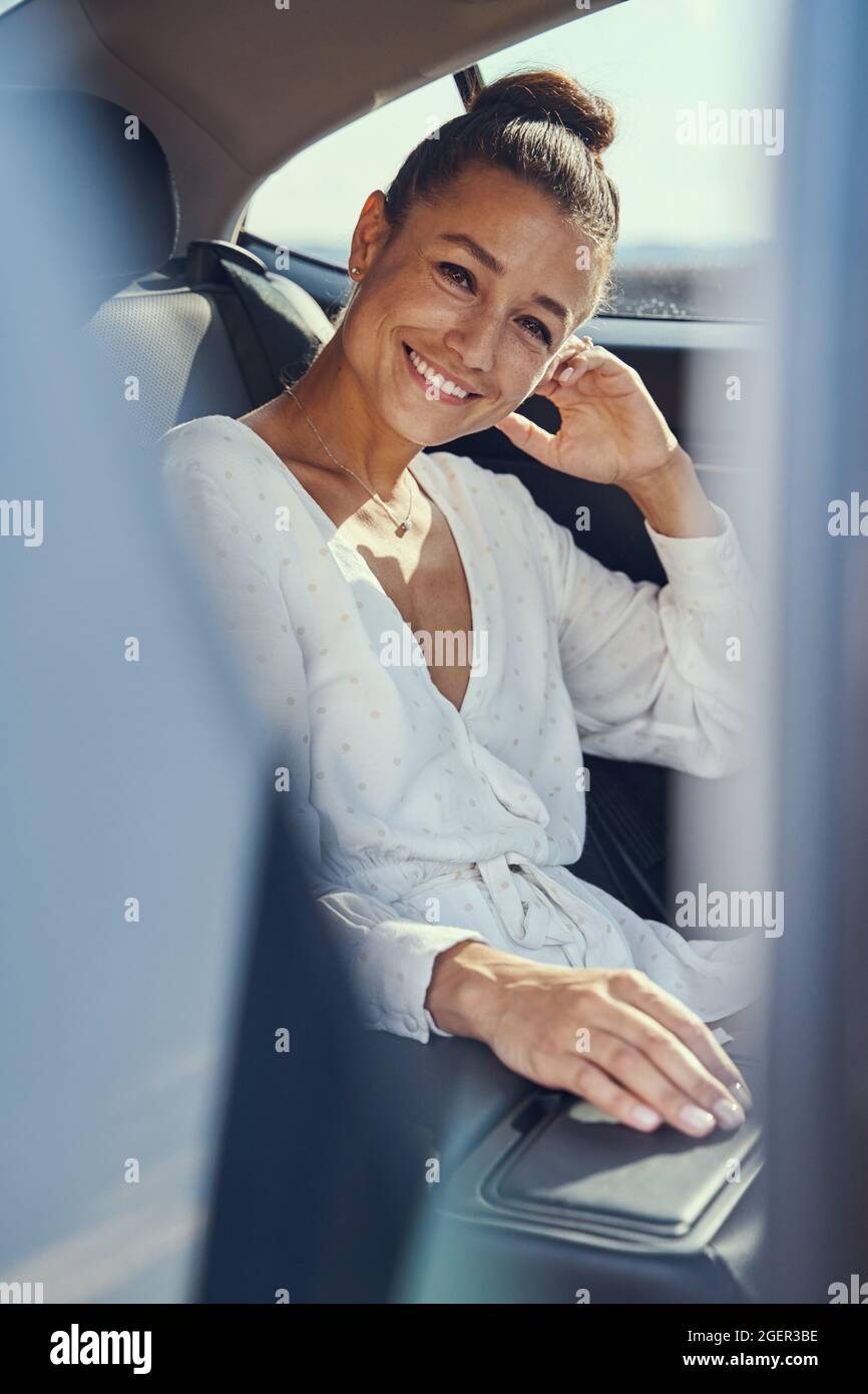 Female in car smiling for a photo from rear seat Stock Photo - Alamy