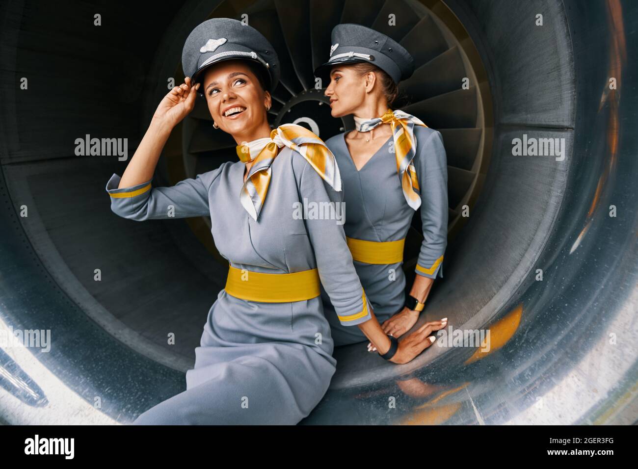 Air hostesses in pilot caps sitting in the turbofan engine Stock Photo ...