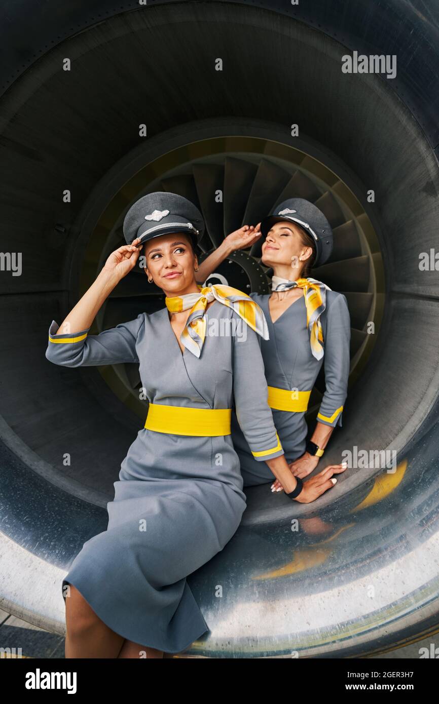 Two flight attendants in pilot caps seated in the aeroengine Stock ...
