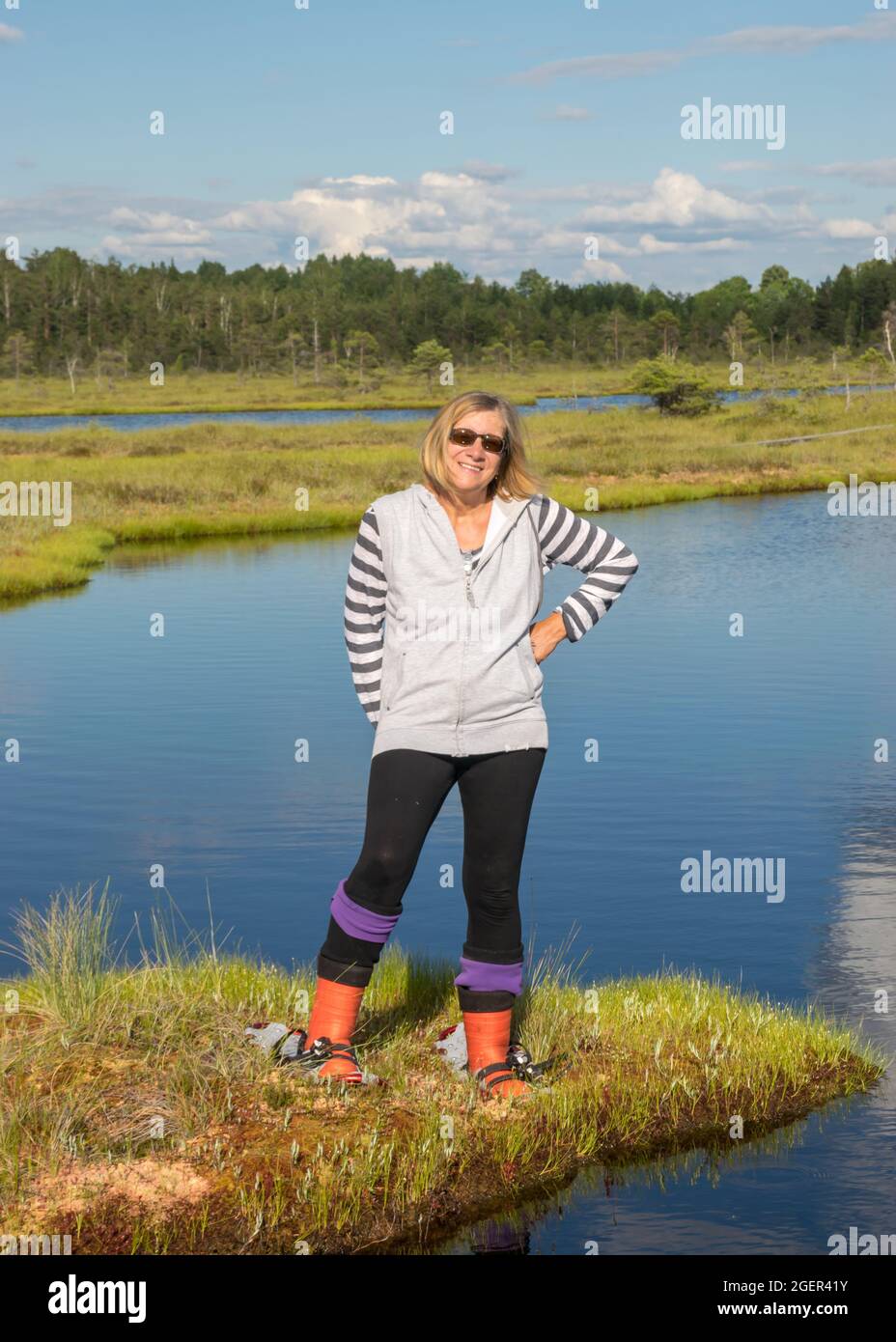 beautiful swamp landscape with blue sky and water, woman enjoys swamp ...