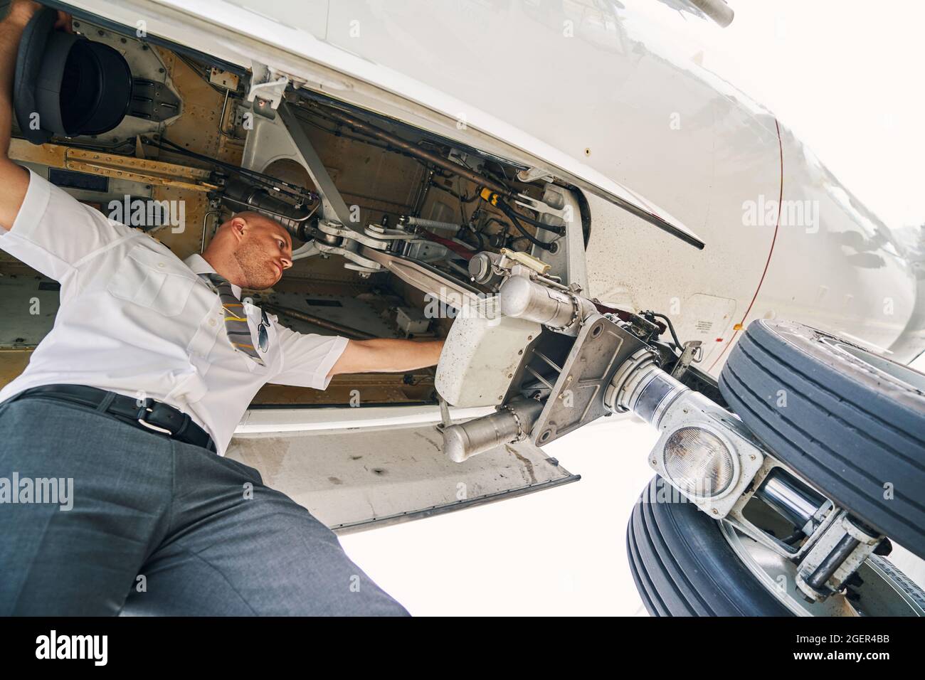 Professional aviator inspecting the aircraft undercarriage before the ...