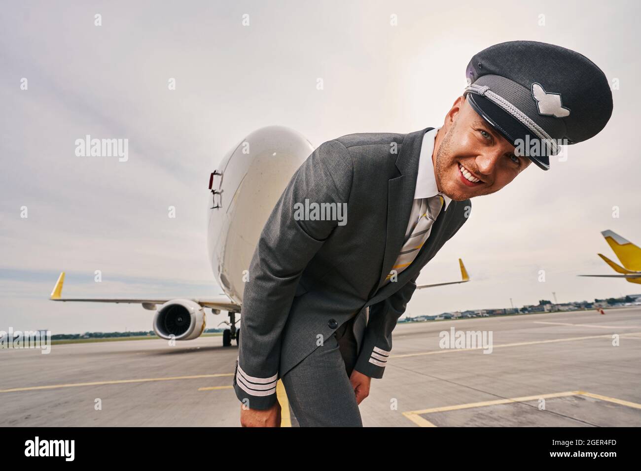 Cheerful attractive airline captain in uniform on the runway Stock ...